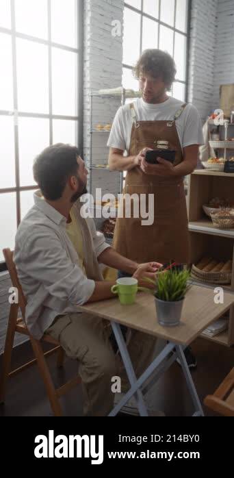 Man ordering from waiter in a cozy bakery cafe with baked goods on ...