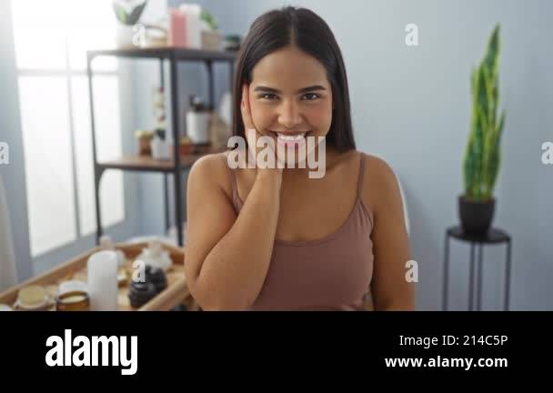 Woman smiling in spa room with brunette hair and wearing a tank top ...