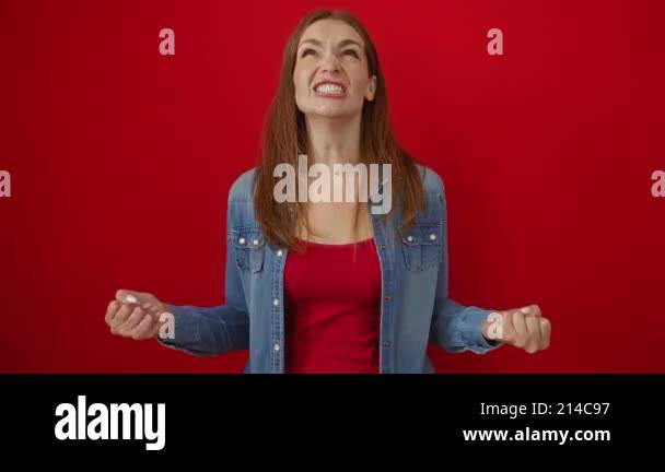 Woman expressing strong emotions with closed eyes and fists clenched in ...