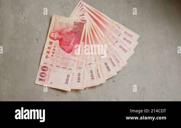 Chinese yuan banknotes spread out in a fan shape on a concrete surface ...