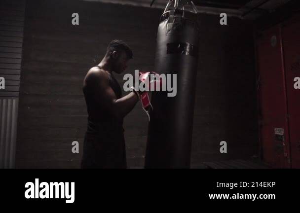 tired african american athletic man hugging punching bag and feeling ...