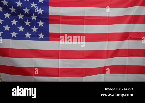 A civilian and a soldier shaking hands in front of an american flag ...