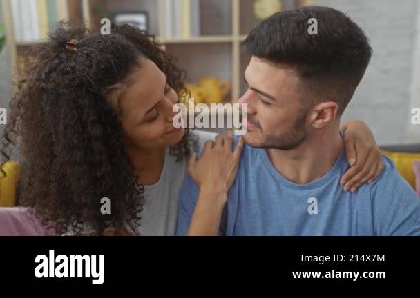 A loving couple enjoys a tender moment together in their cozy living ...