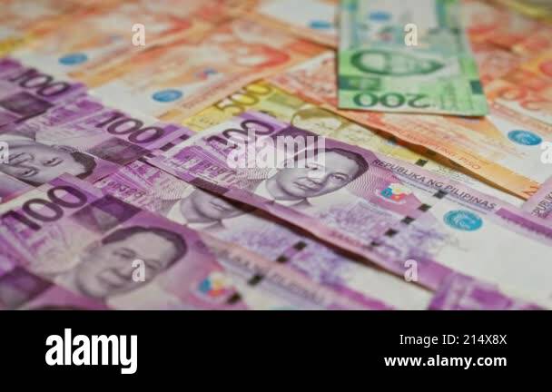 Philippine banknotes of various denominations spread out showcasing ...