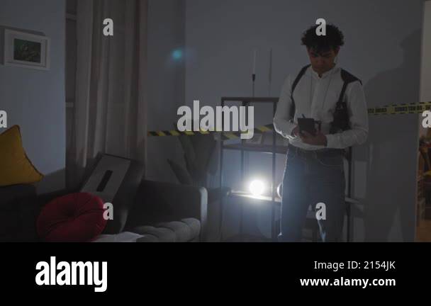 Hispanic man stressed at crime scene in apartment with lamp, notepad ...