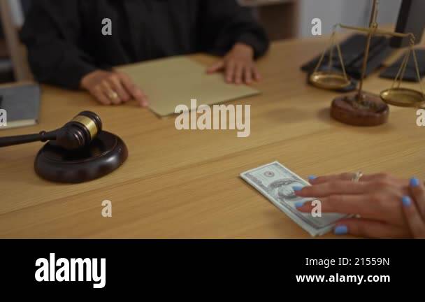 Judge receiving stack of hundred dollar bills from woman in office with ...