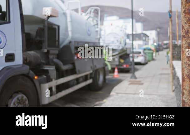 Blurred image of a sewer cleaning tanker truck parked on a street with ...
