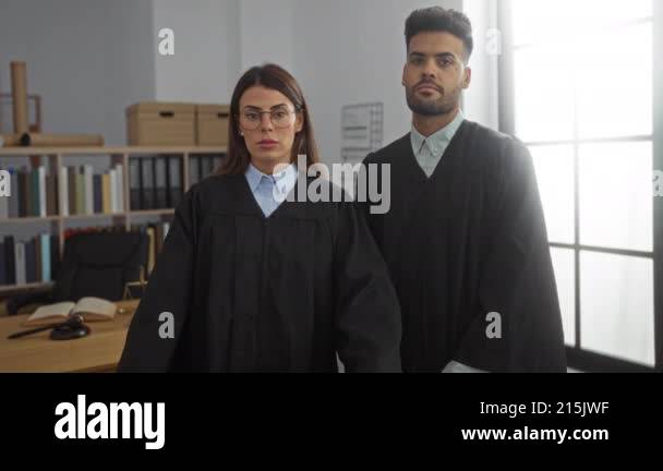 Male and female judges standing with crossed arms in a law office ...