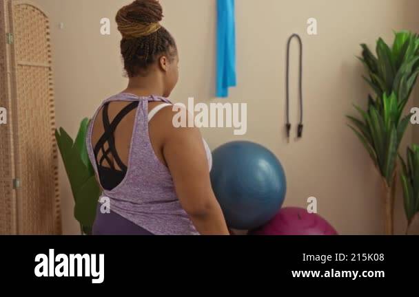 Plus size woman exercising in an indoor gym, surrounded by fitness ...