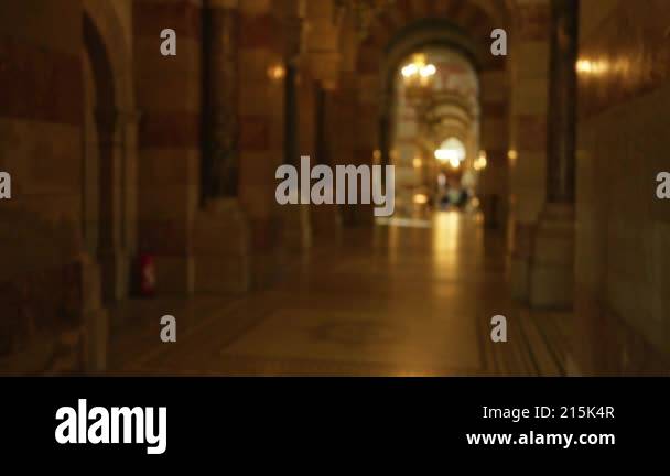 Blurry interior of a grand church hallway with soft lighting and arched ...