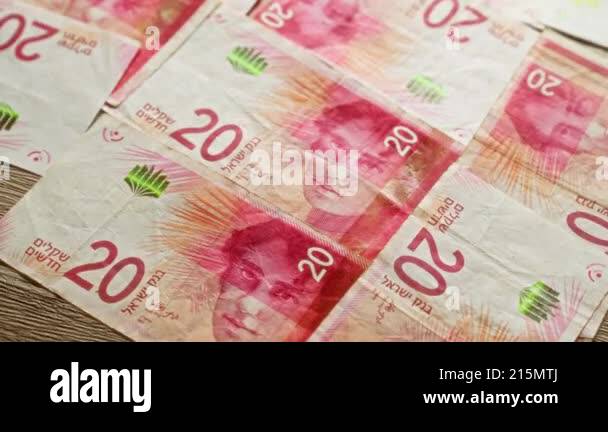 Israeli shekel banknotes spread out on a wooden table, featuring the 20 ...