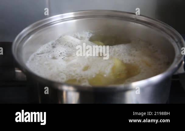 A pot of boiling water on the stove is ready for cooking various ...