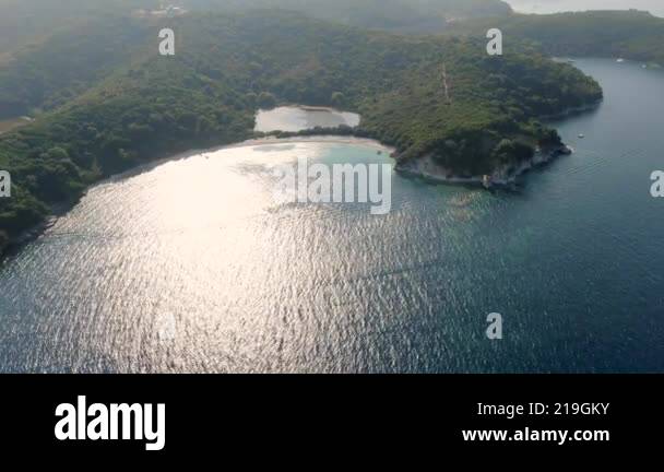 Aerial view of a secluded coastal lagoon nestled between lush green ...