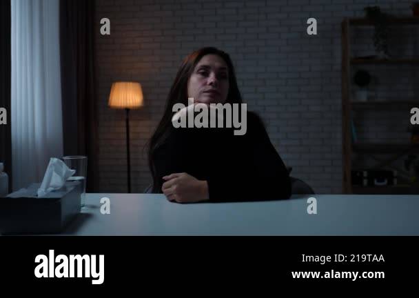 Depressed woman in dark apartment. Woman suffering mental health issues ...