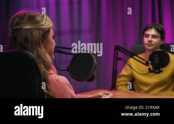 Online podcast. Man host and woman guest recording interview in loft ...