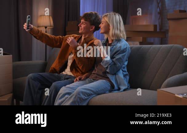 A young man and woman are in the living room discussing a housewarming ...