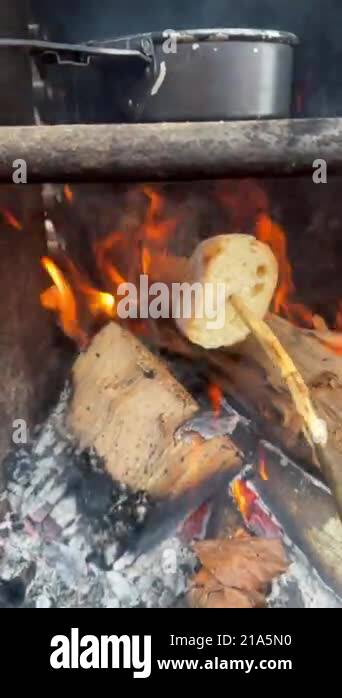 A cozy forest moment with bread roasting on a stick and tea brewing in ...