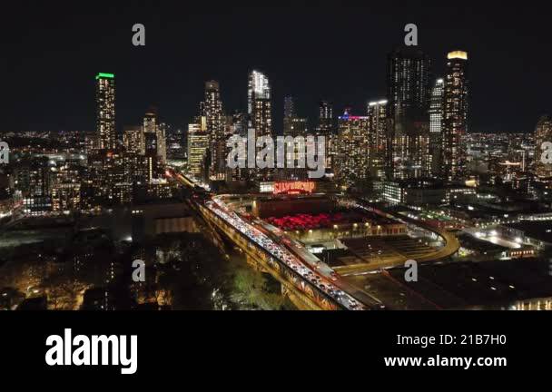 Camera pans across the illuminated Long Island City skyline at night ...