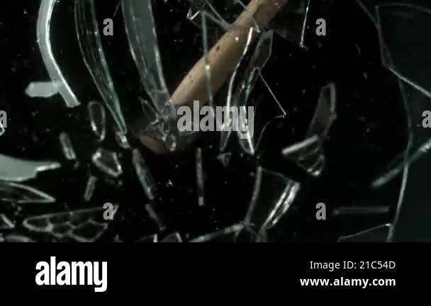 Super slow motion of glass-breaking hammer, shattering against black ...