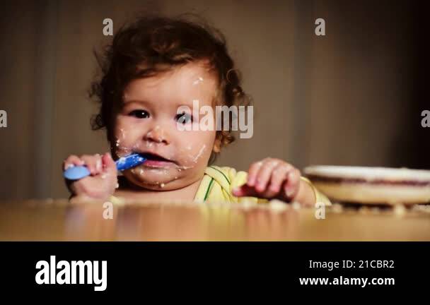 Baby eats with a spoon. Child have a meal. Hungry little kid eating ...