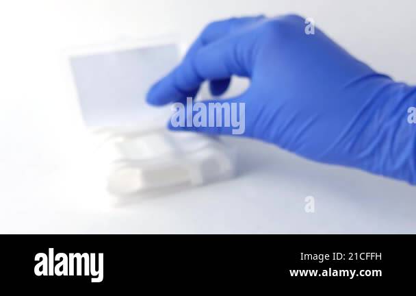 Doctor's hand takes flosser out of plastic container close-up on white ...