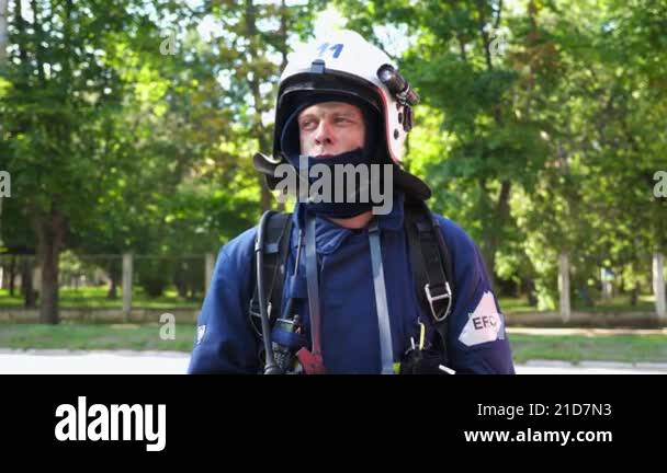 Portrait of tired male firefighter in protective uniform standing ...