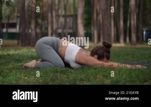 A peaceful scene of a woman practicing the childs pose during her yoga ...