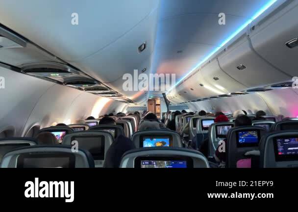 The interior of the aircraft with spacious seats and multiple entertainment screens ...