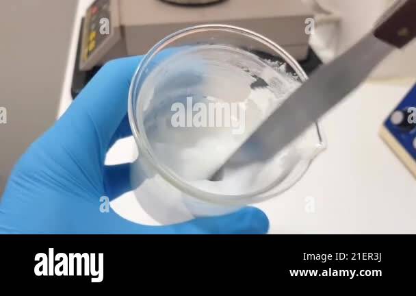 Close-up footage of a beaker containing a white emulsion being stirred ...