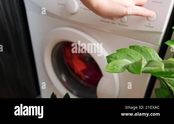 Woman in orange apron turns on washing machine, modern washing machines ...