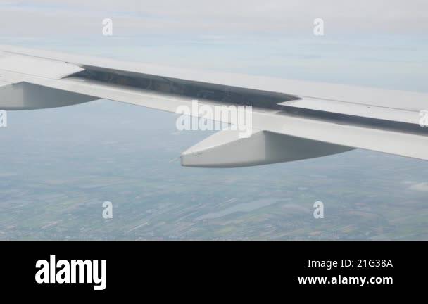 view through airplane window with wing view while spoiler air break was ...