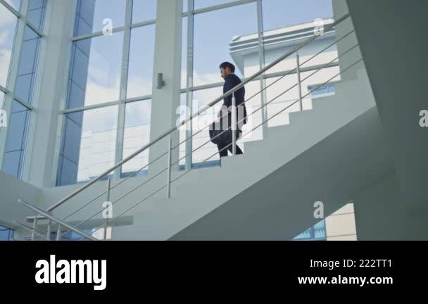 Businessman hurrying work meeting walking down staircase modern office ...
