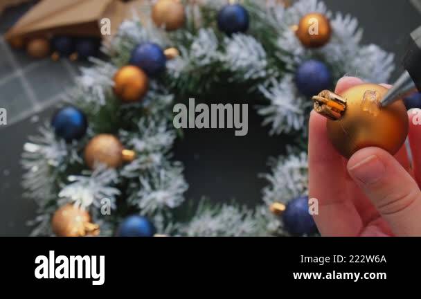 Crafter using hot glue Handmade Christmas wreath from festive blue and ...