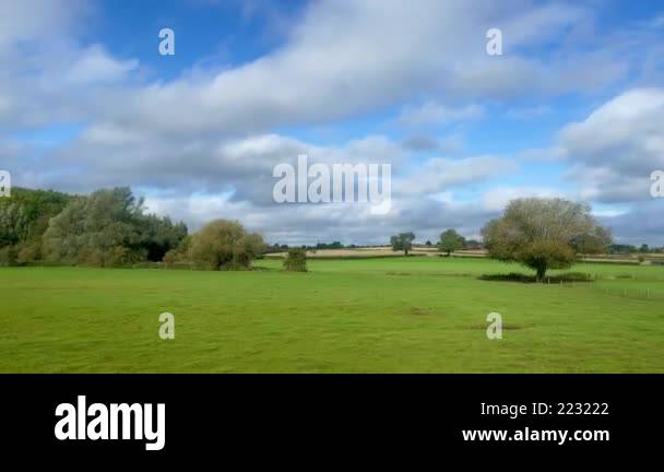 English countryside view featuring open fields, scattered trees, and a ...