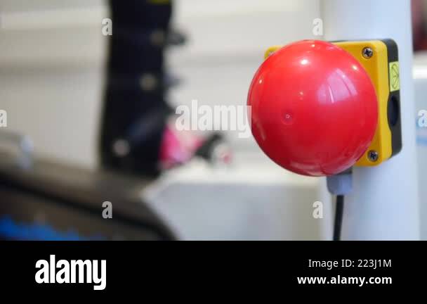 Here is a closeup view of a bright red emergency stop button designed ...
