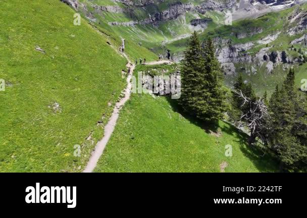 Drone hovering above some hikers on a mountain trail high above the ...