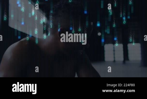 Binary code animation over person working on computer in dark room ...