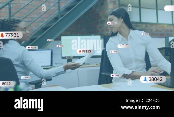 Exchanging documents, businesswomen in office with social media ...