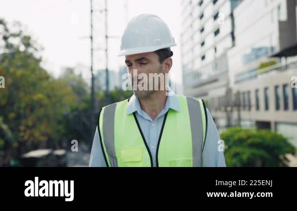 Portrait of smiling caucasian man engineer against high-rise building ...