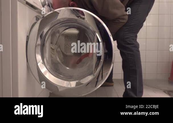 Stockholm, Sweden A man unloads a washing machine and loads a dryer in ...