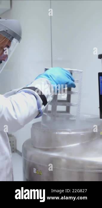 vertical Scientific professional handling liquid nitrogen while ...
