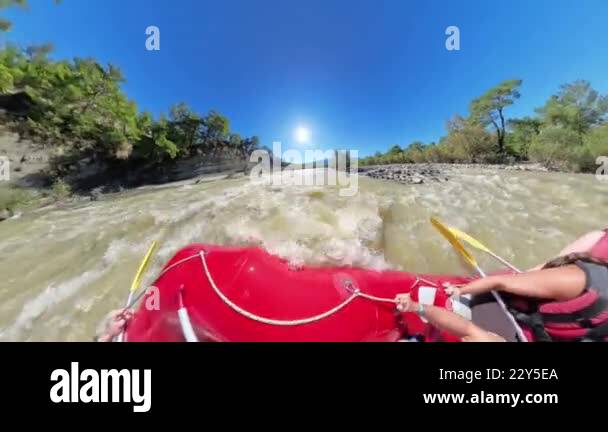 A front-facing view from a rafting boat moving down a wide river ...