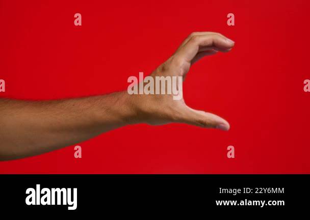 Man hand isolated on bright red background with a grasping gesture ...