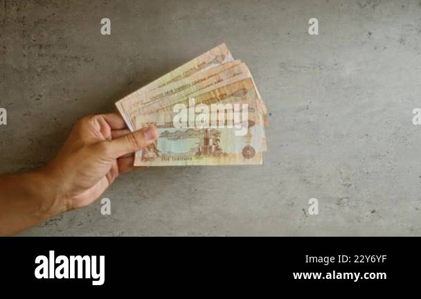 Hand holding united arab emirates dirham bills against a concrete ...