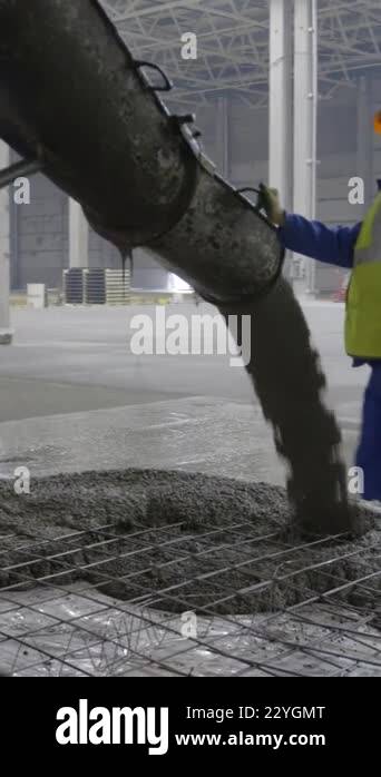 Skilled workers meticulously pour concrete across a vast construction ...