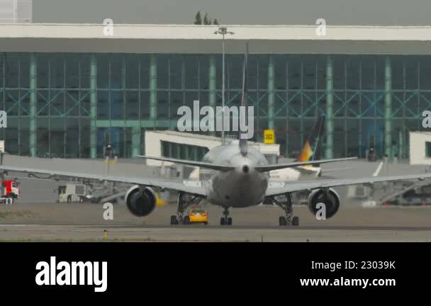 Rear view of jet passenger plane taxiing behind car Follow me. Airplane ...