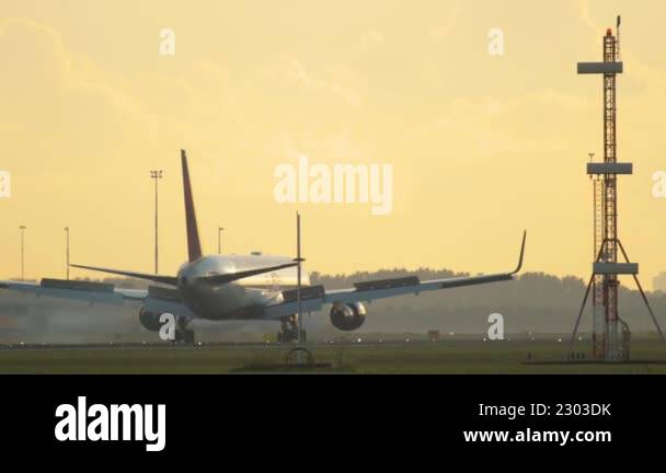 Landing and braking of the plane in the golden sunset. Slowing down ...