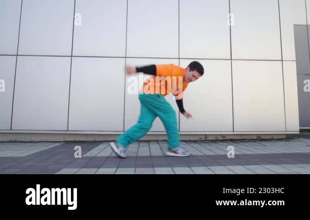young energetic guy dancer breakdancing outdoors in the city on the ...