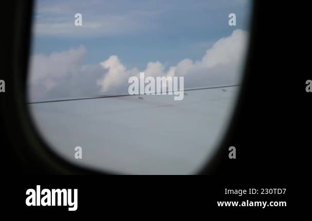 View From Airplane Window Capturing Wing and Scenic Clouds During Flight Across Sky. Plane ...