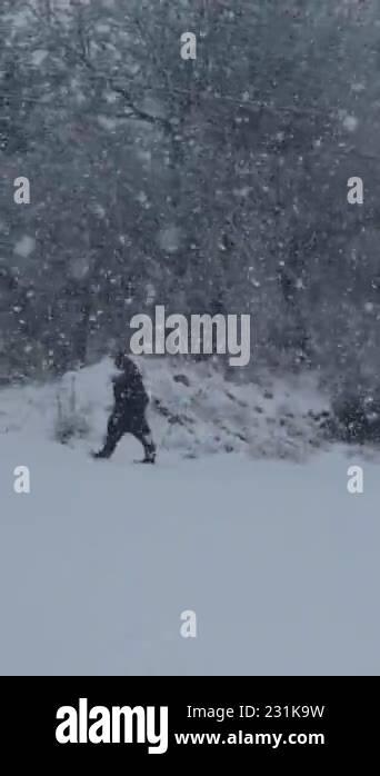 Man trying to escape under heavy snowfall, male walking under snowfall ...